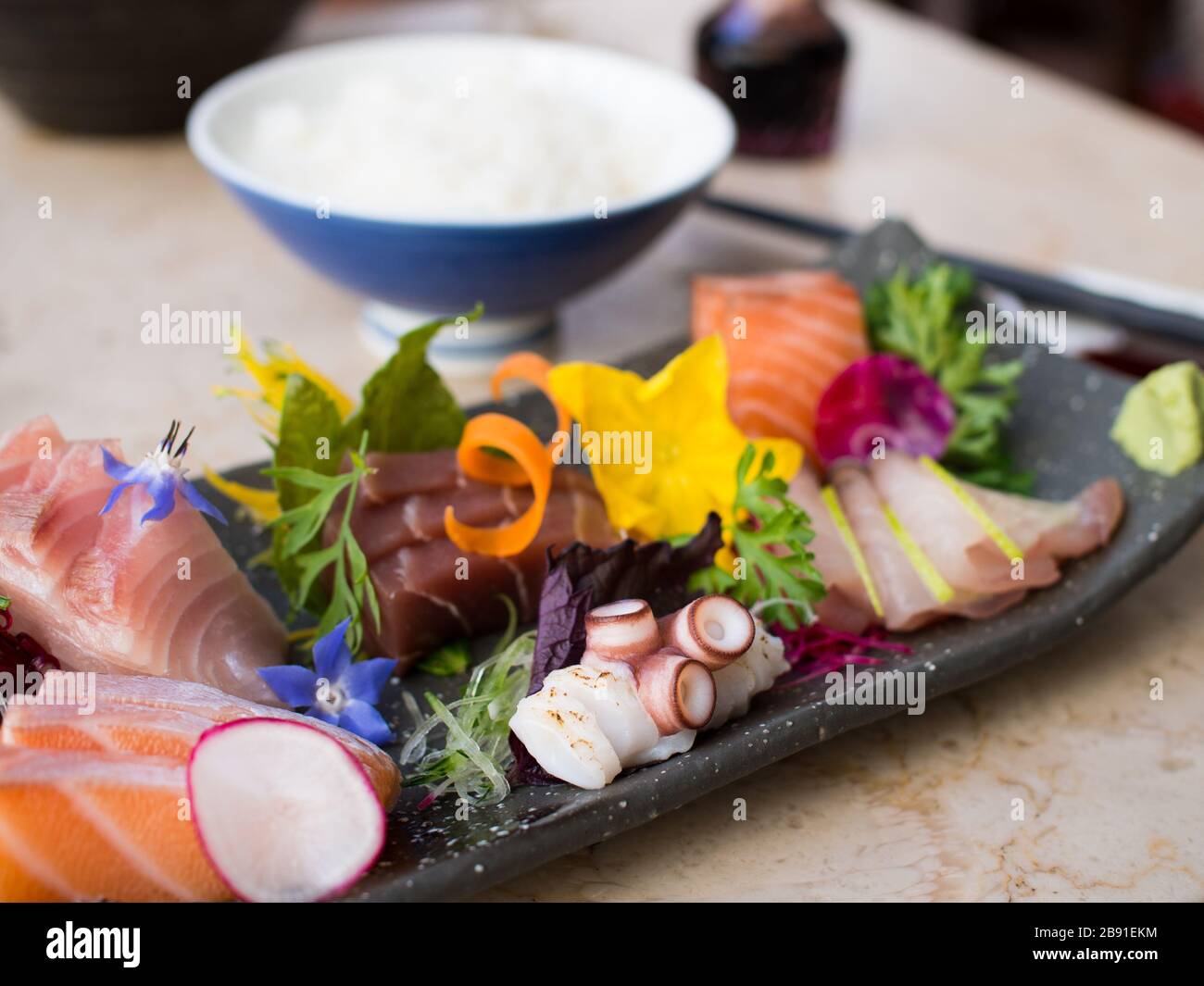 Japanese raw fish on black plate. Also known as Sashimi Stock Photo - Alamy