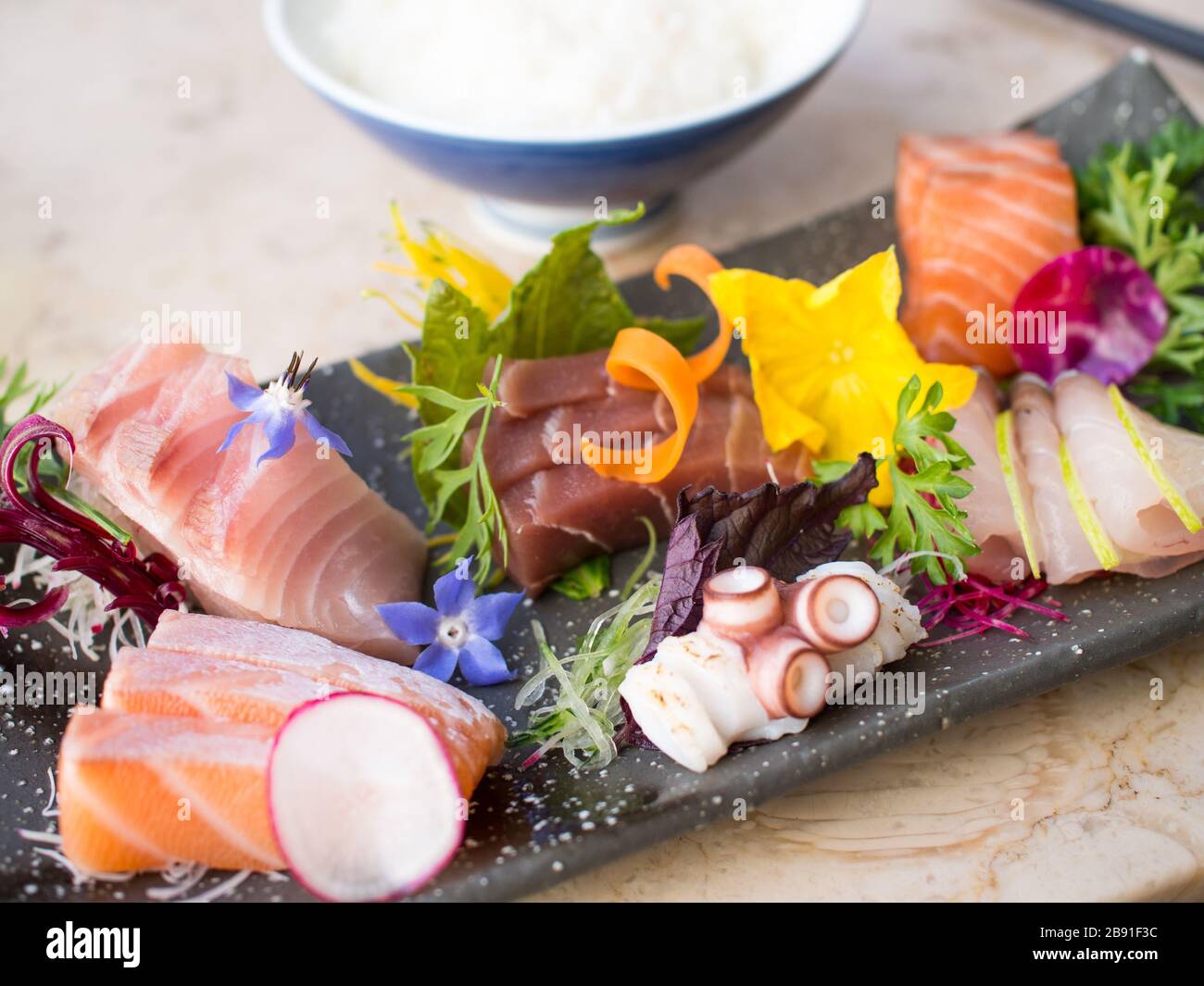 Japanese raw fish on black plate. Also known as Sashimi Stock Photo - Alamy