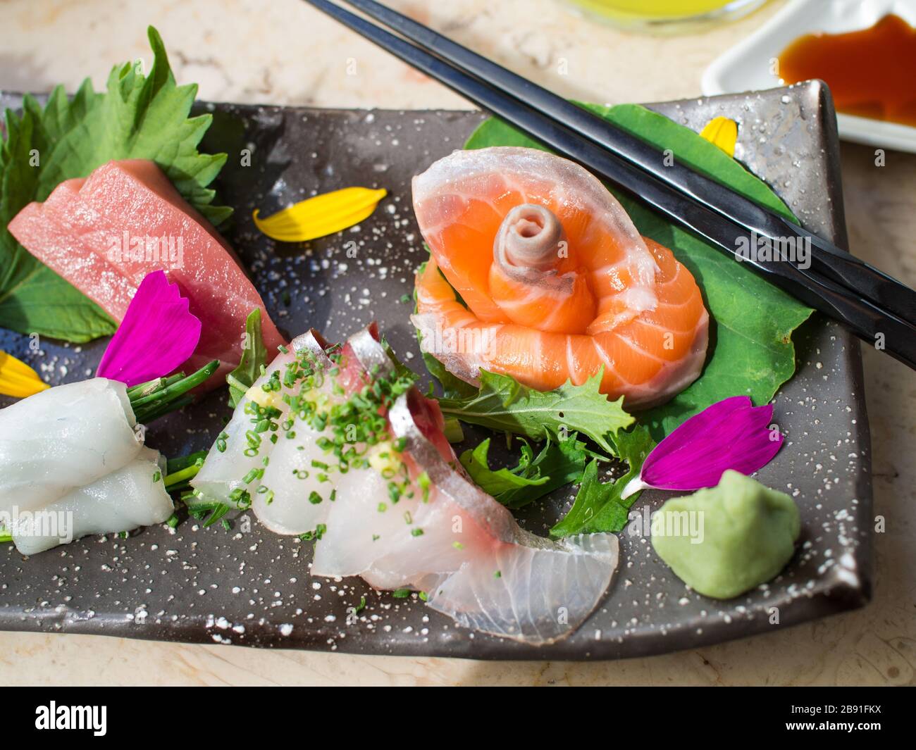 Japanese raw fish on black plate. Also known as Sashimi Stock Photo - Alamy