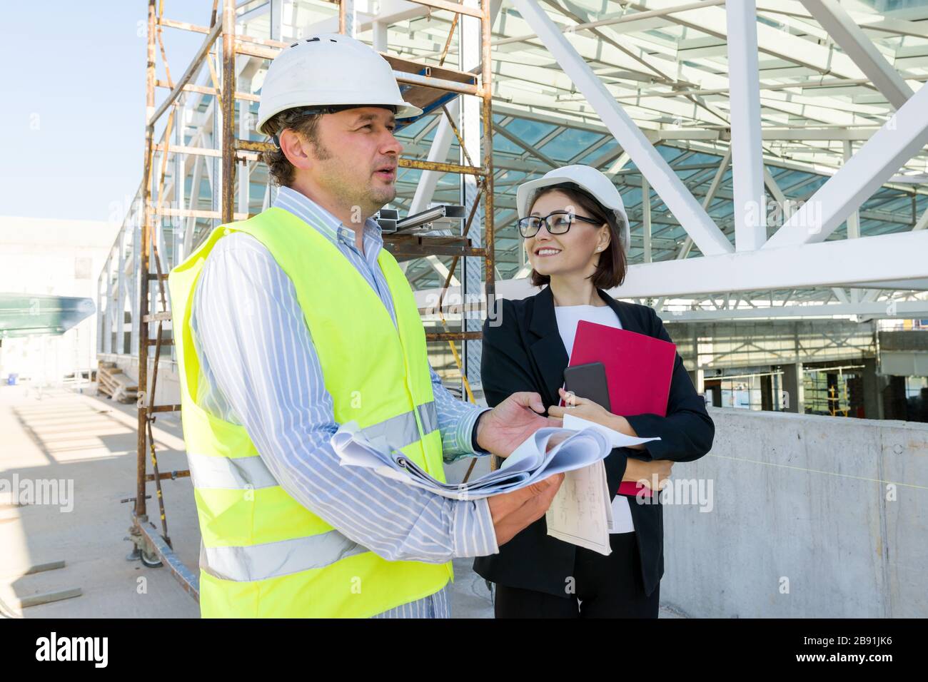 Construction, man and woman builders at construction site, team of ...