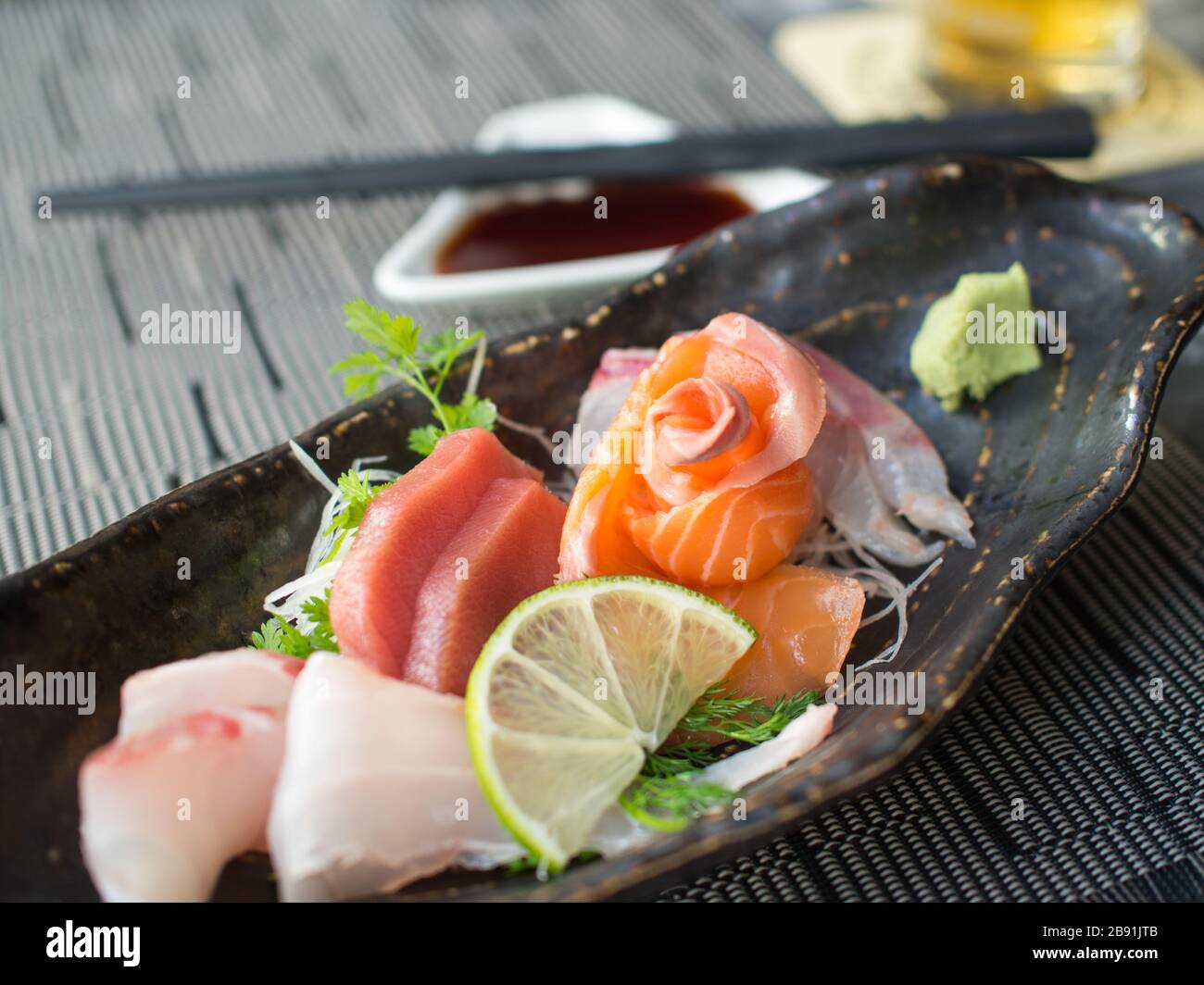 Japanese raw fish on black plate. Also known as Sashimi Stock Photo - Alamy