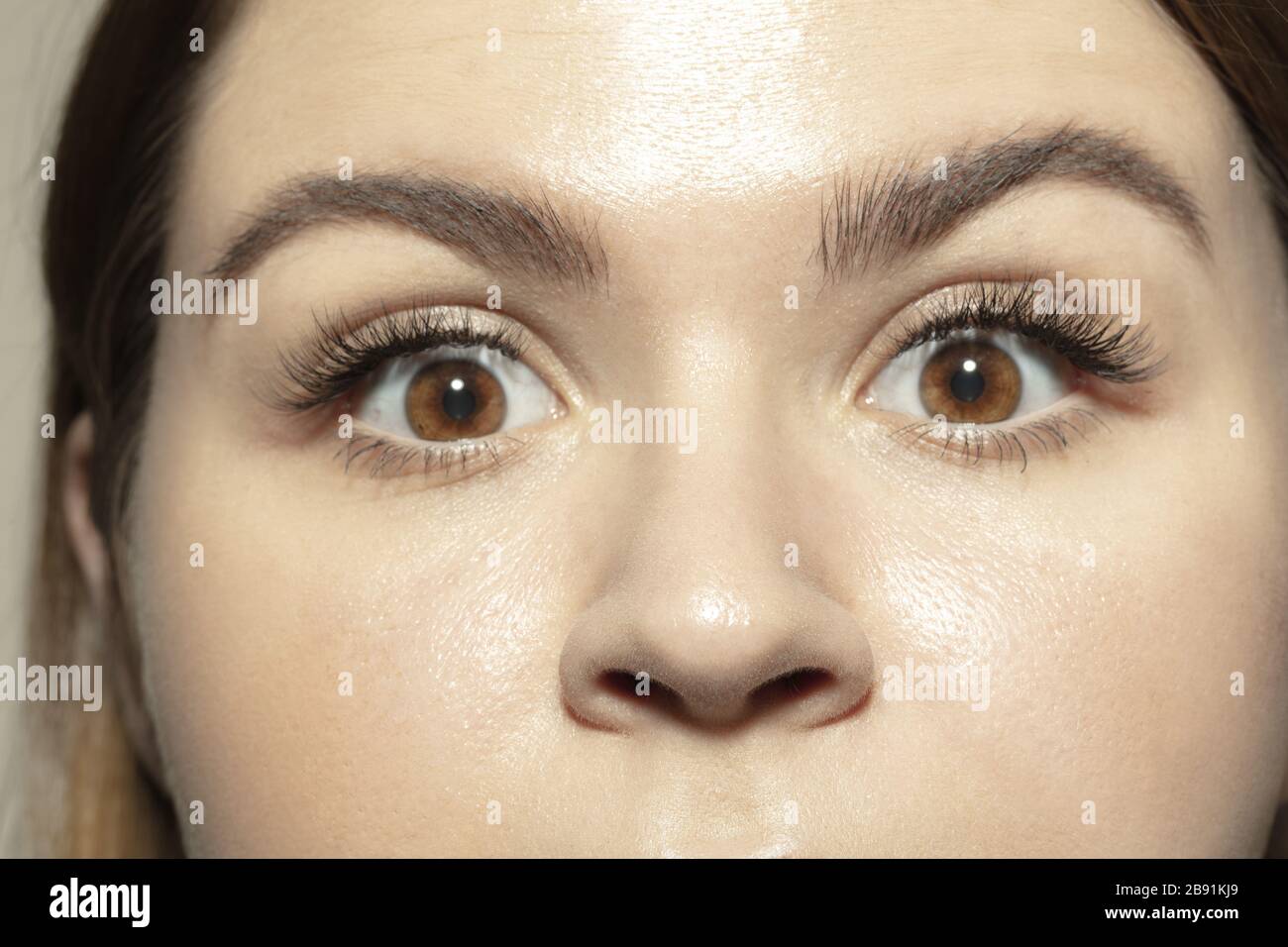 Shocked. Close up of face of beautiful caucasian young woman, focus on ...
