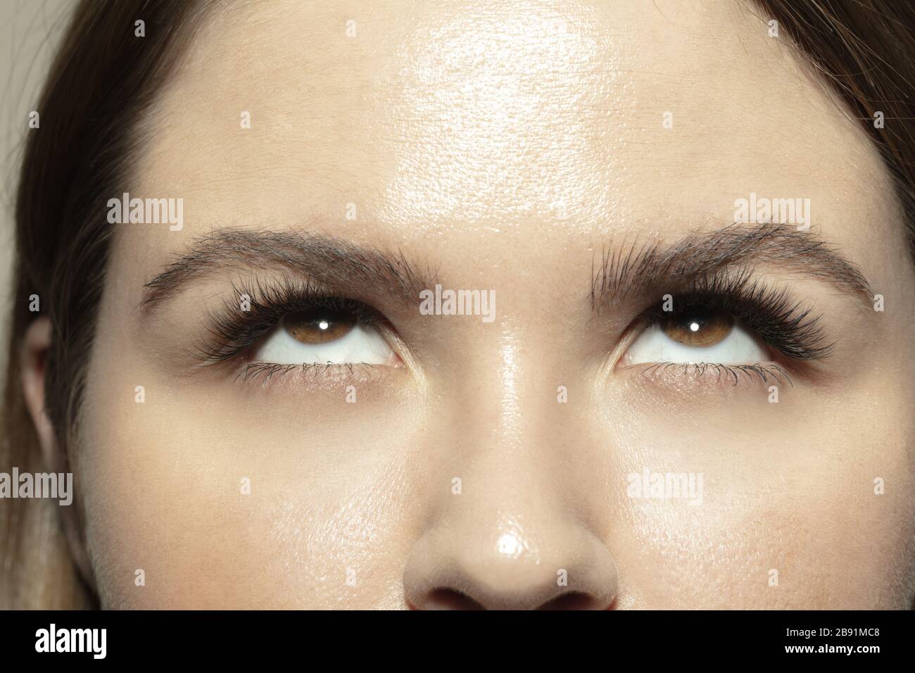Looking up. Close up of face of beautiful caucasian young woman, focus ...