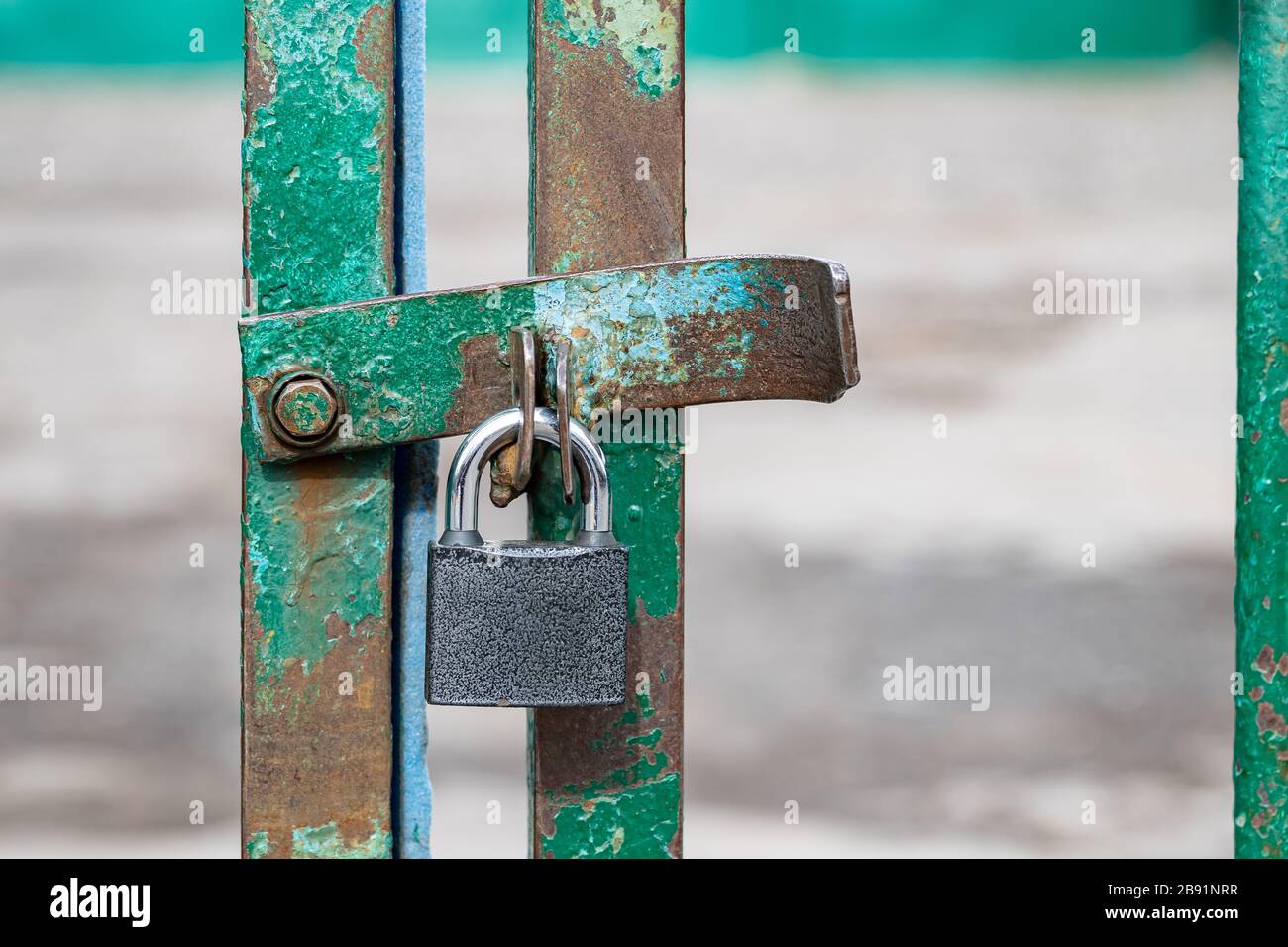 Closed and locked door grill with silver padlock. A metal lock on ...