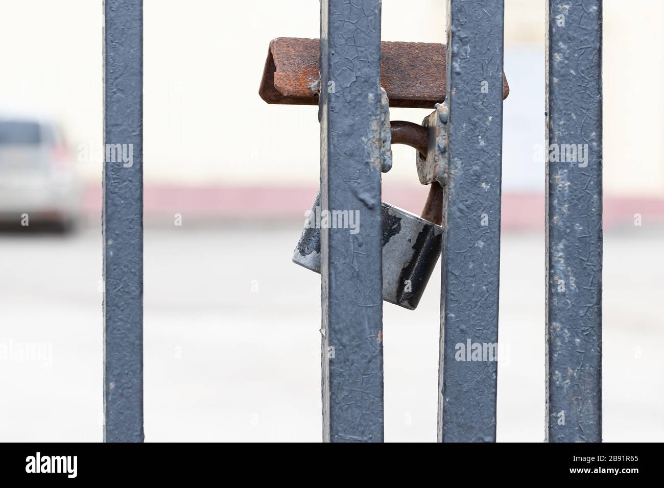 Closed and locked door grill with silver padlock. A metal lock on ...