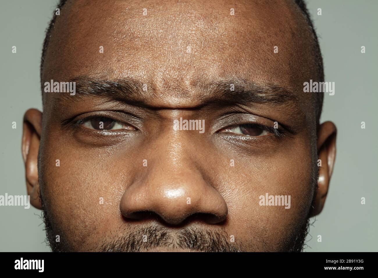 Asking. Close up of face of beautiful african-american young man, focus ...