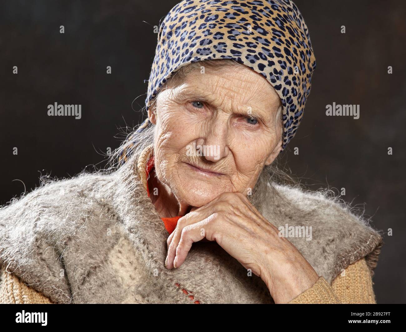 Close up portrait of old woman with thoughtful look on dark background ...