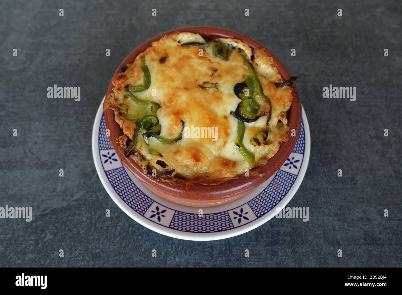 Pasta with melted cheese and green peppers. Oven baked italian food ...