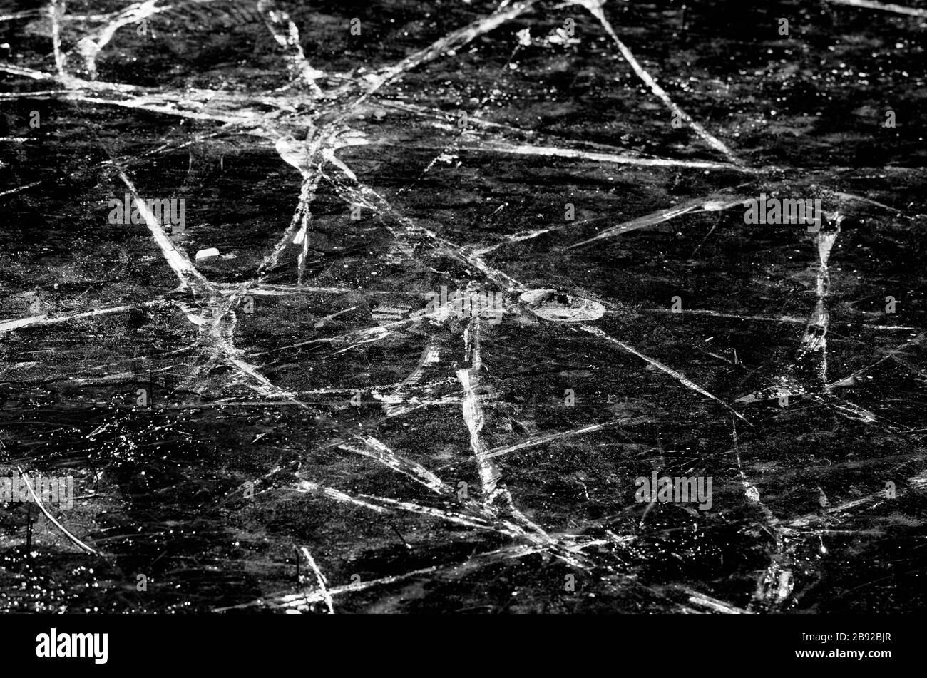 Natural pattern of cracks on the ice cover of the river in black and ...