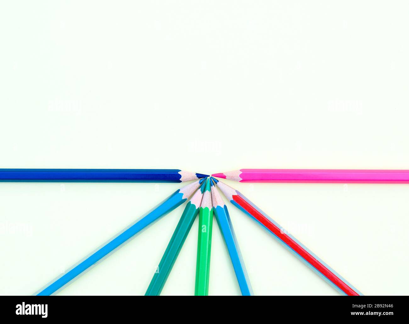 Seven different colored pencil crayons arranged in a half circle shape ...