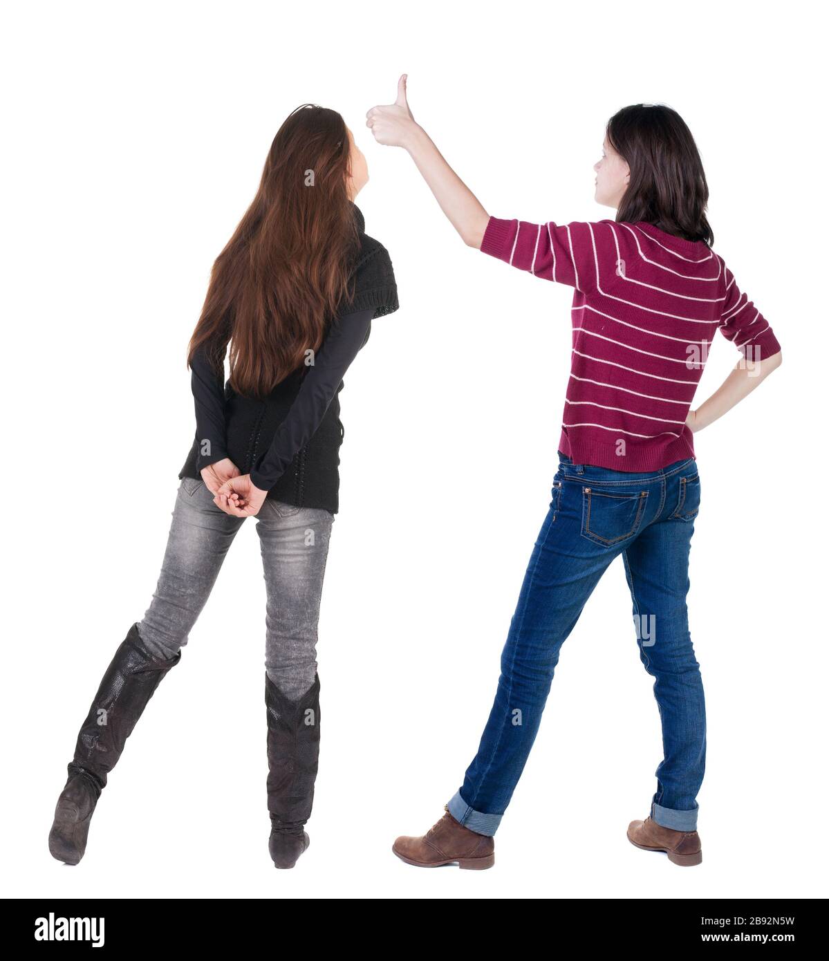 Back view of two pointing girl in sweater. Rear view people collection ...