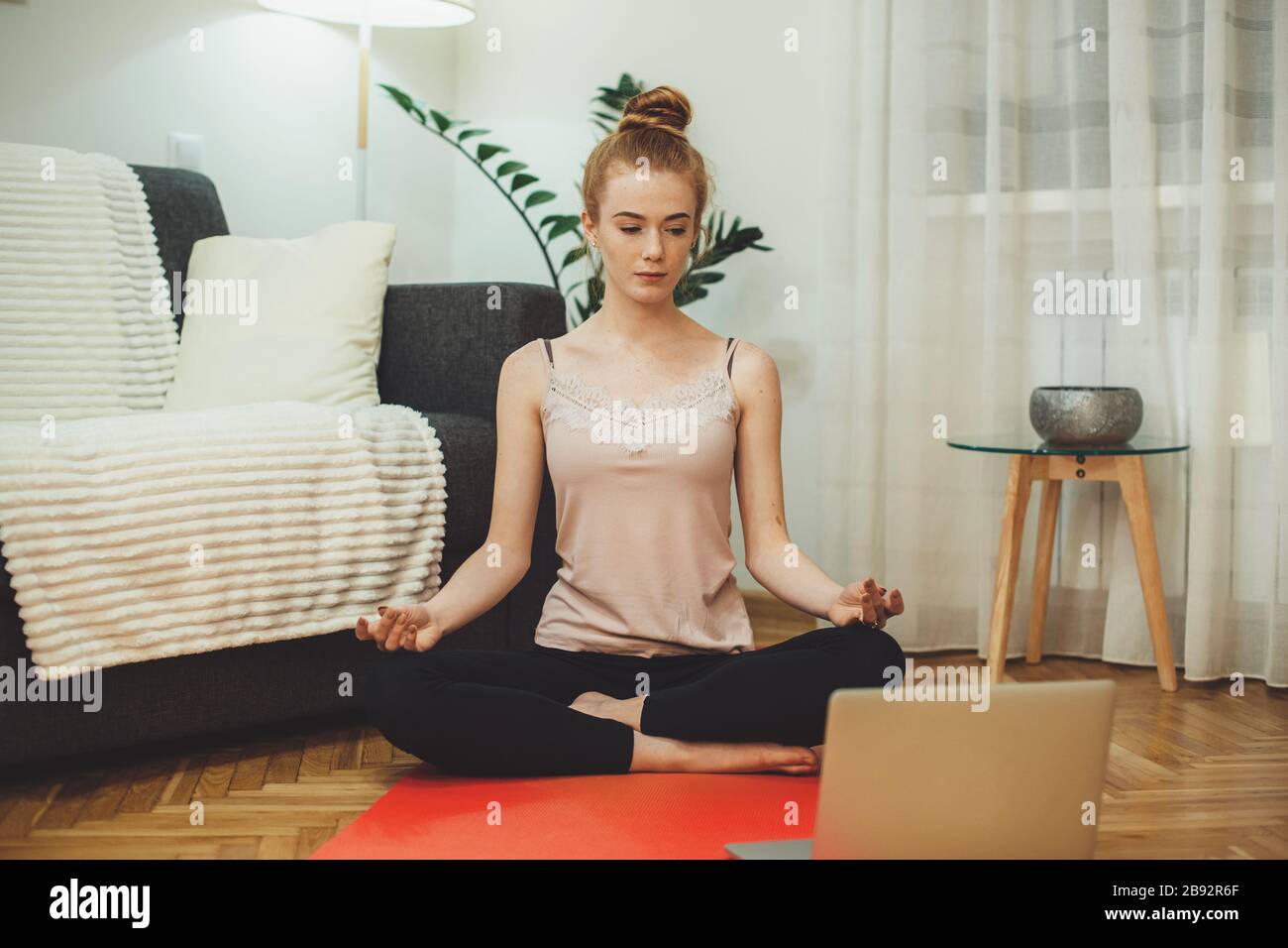 Ginger caucasian girl with freckles is having some online yoga lessons ...