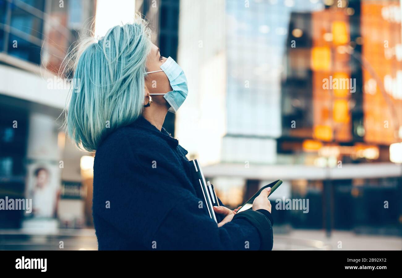 Close up portrait of a looking up woman with blue hair wearing a anti ...