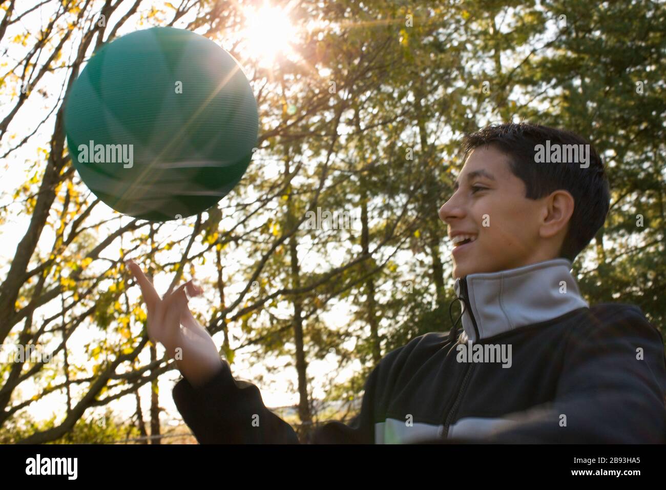Teenage boy spinning basketball on one finger Stock Photo - Alamy