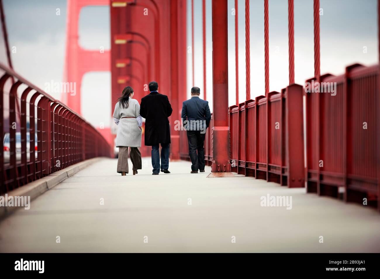 Three friends walk together on the Golden Gate Bridge, San Francisco ...