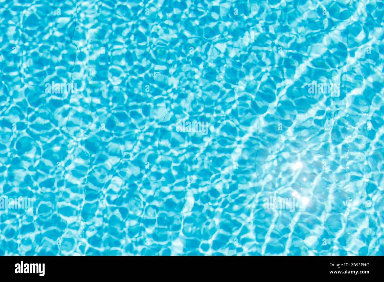 Surface of blue shining swimming pool water ripple and sun reflection ...