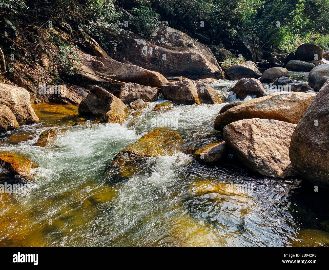A small mountain river flows among large stones in mountainous areas ...