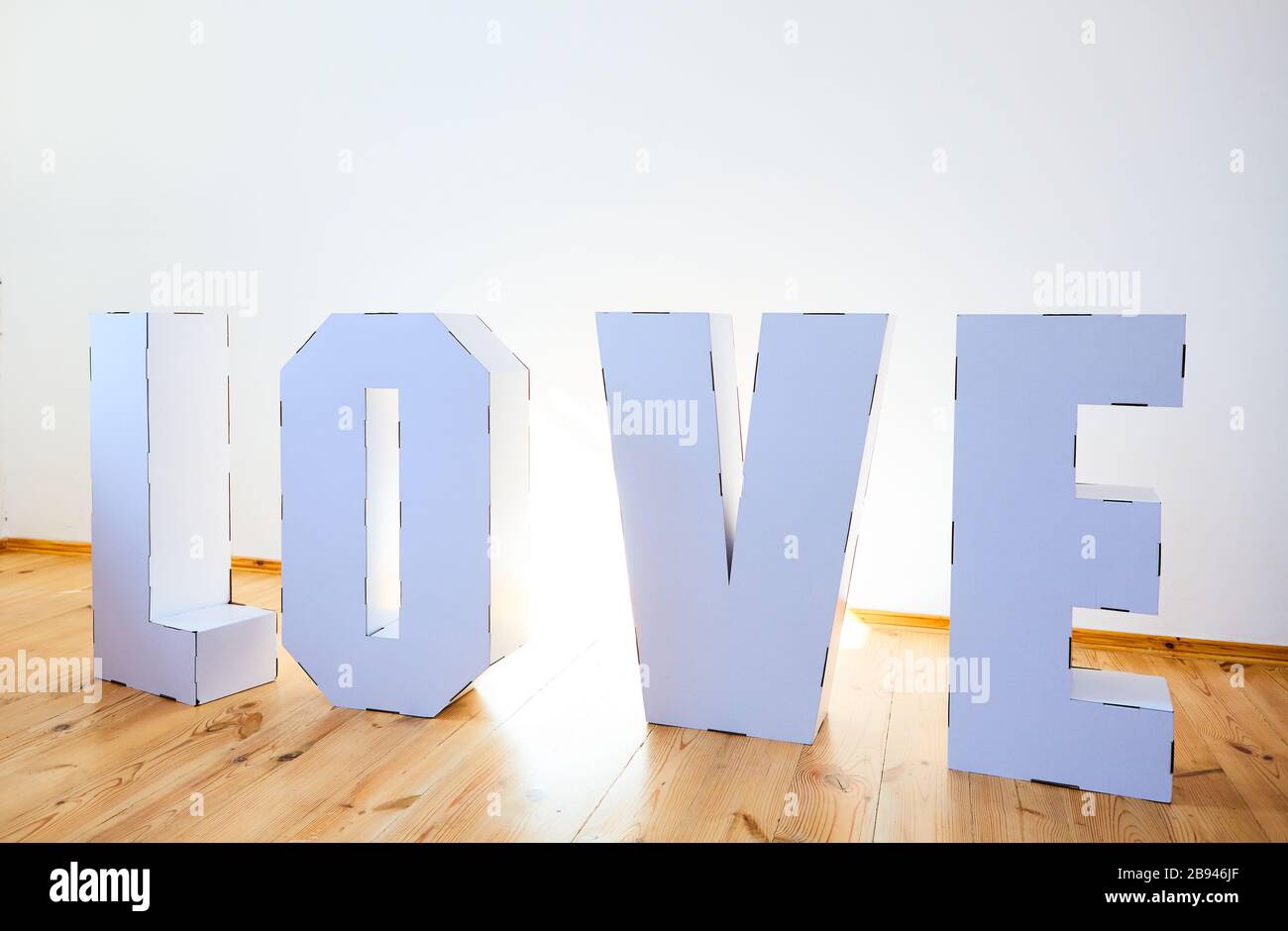 3D Standing Letters forming word LOVE from white cardboard on a light ...