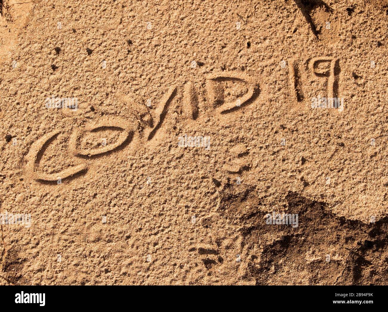 Covid19 name written in sand Stock Photo - Alamy