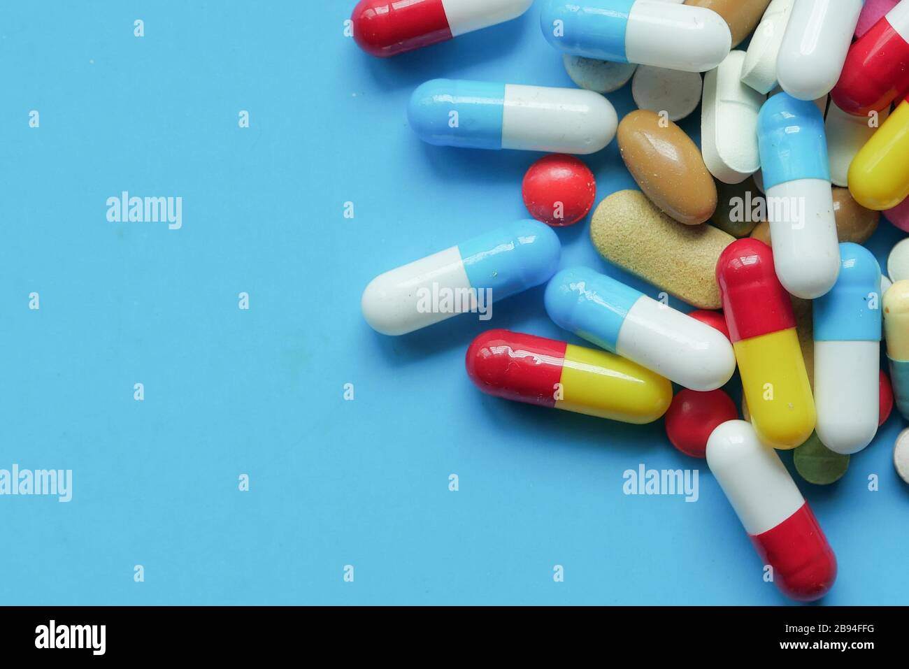 colorful pills spilling on blue background, top view Stock Photo - Alamy