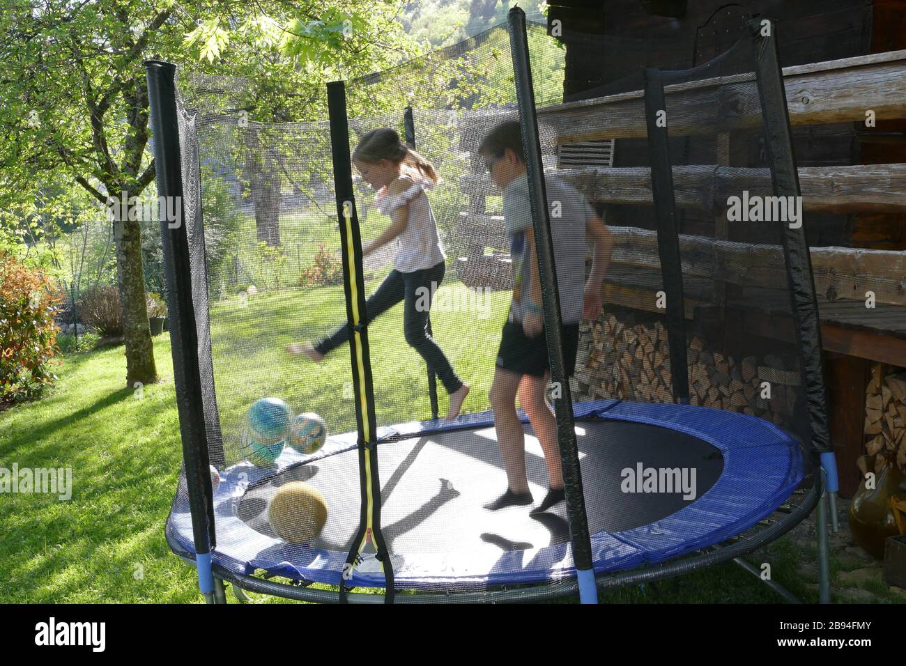 Brother and sister jumping on the trampoline Stock Photo - Alamy