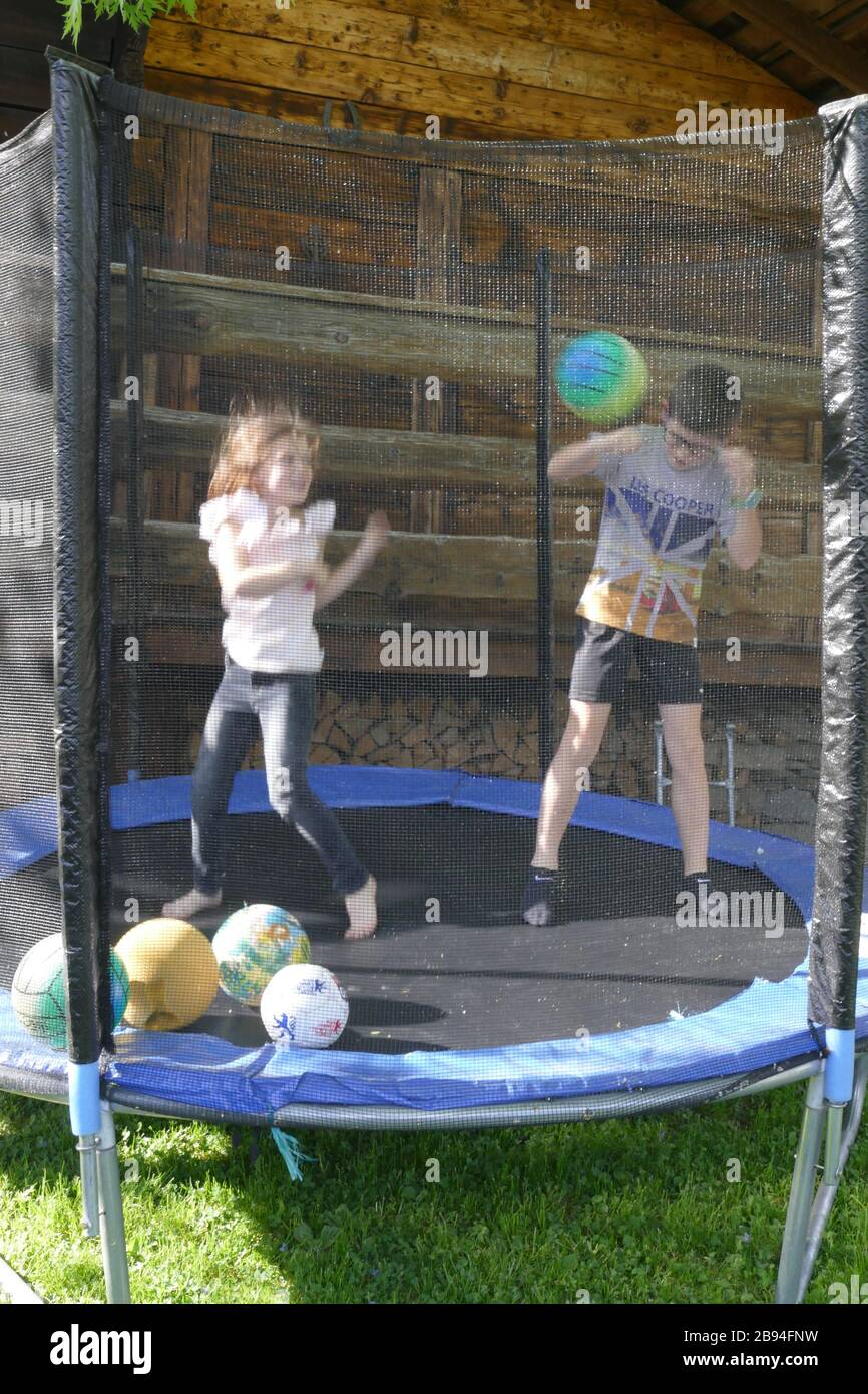Brother and sister jumping on the trampoline Stock Photo - Alamy
