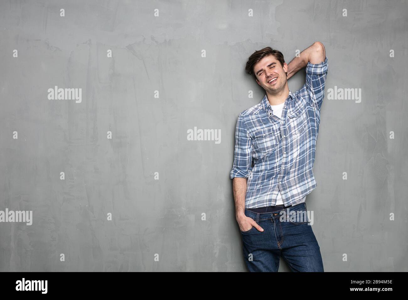 normal young man standing on a grey background concrete wall Stock ...