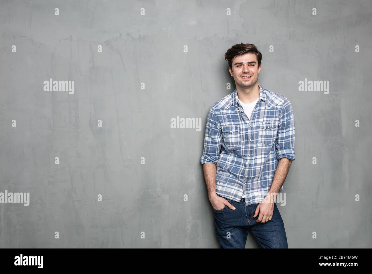 normal young man standing on a grey background concrete wall Stock ...