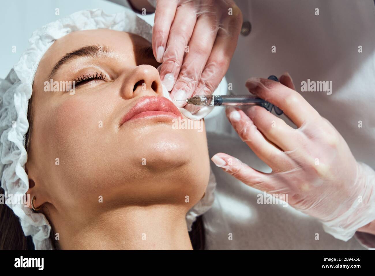 lip shape correction procedure in a cosmetology salon. The specialist ...