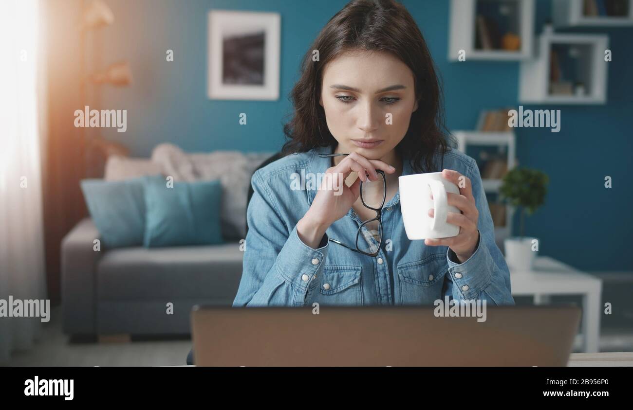 Serious woman looking laptop screen Stock Photo - Alamy