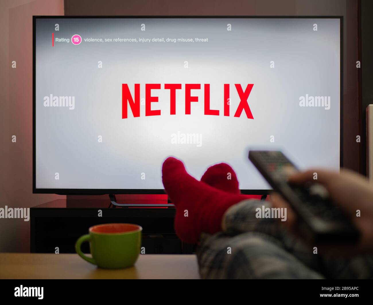 UK, March 2020: TV Television Netflix logo watching with feet up comfy ...