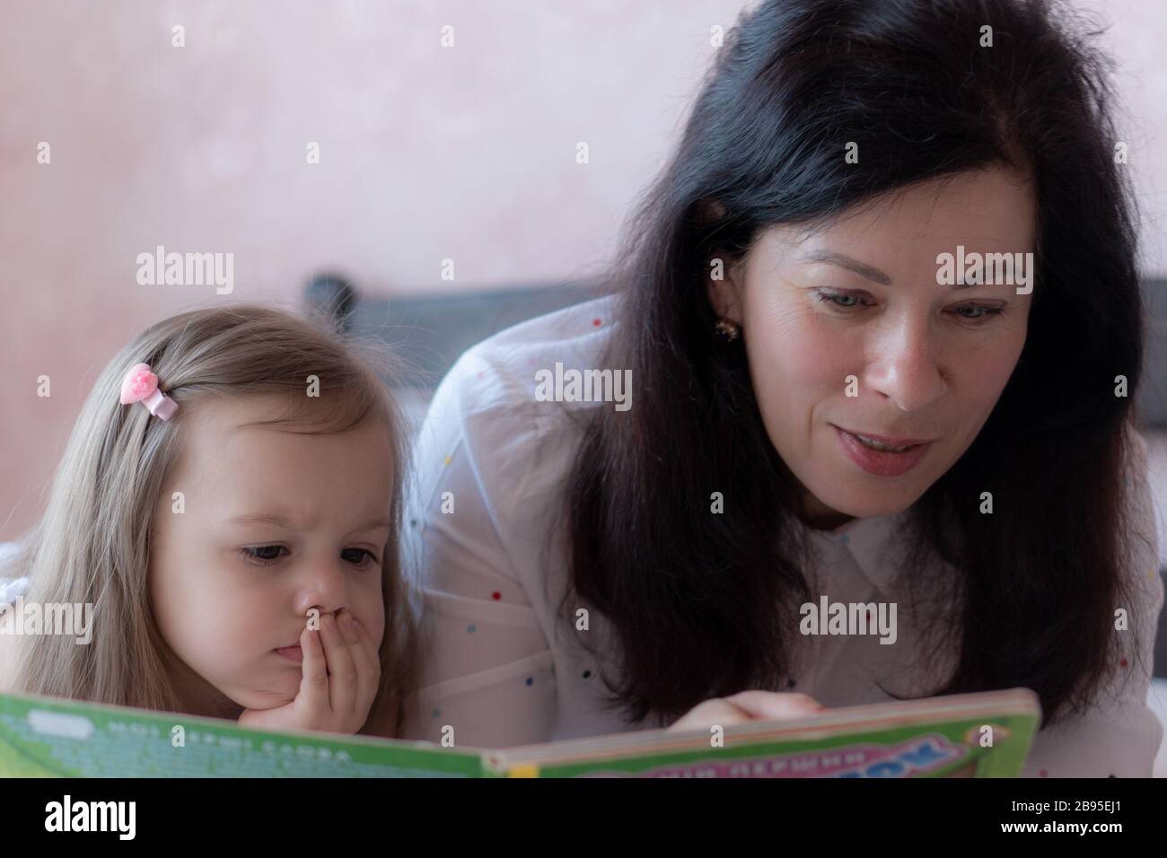 Grandmother with grandson and granddaughter in bed reading a book ...
