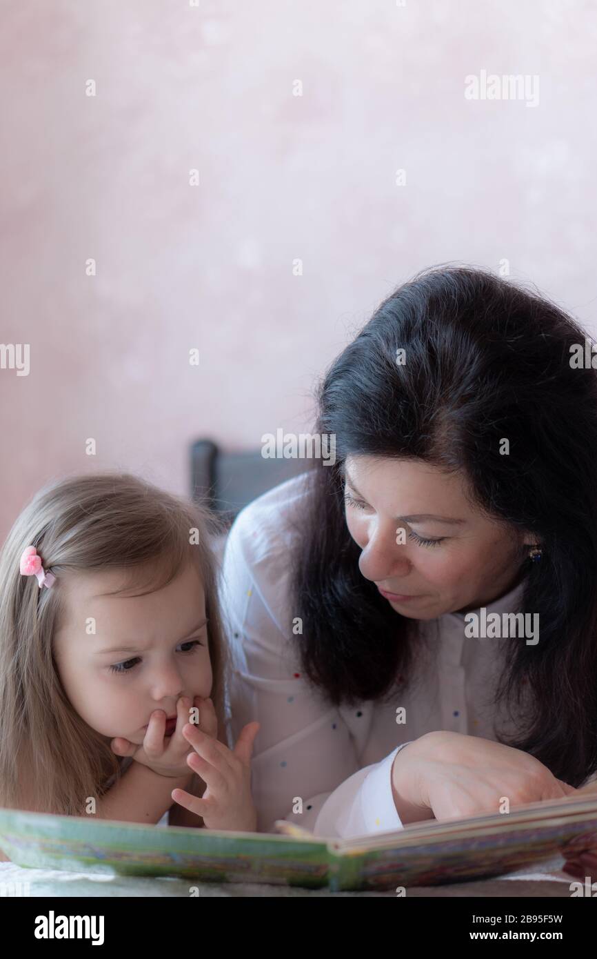 Grandmother with grandson and granddaughter in bed reading a book ...