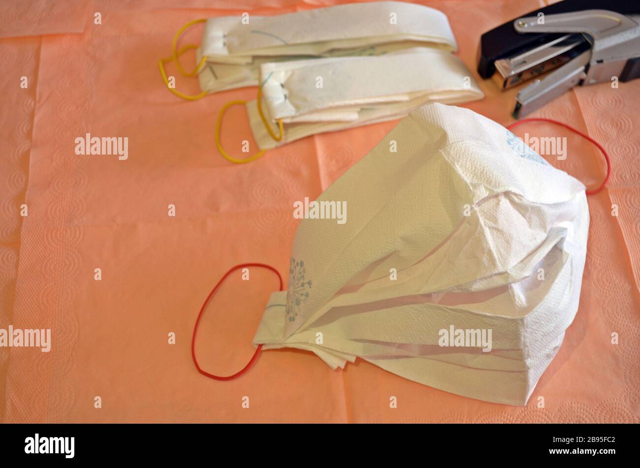 Three homemade DIY surgeon face masks made with napkins, rubber bands ...