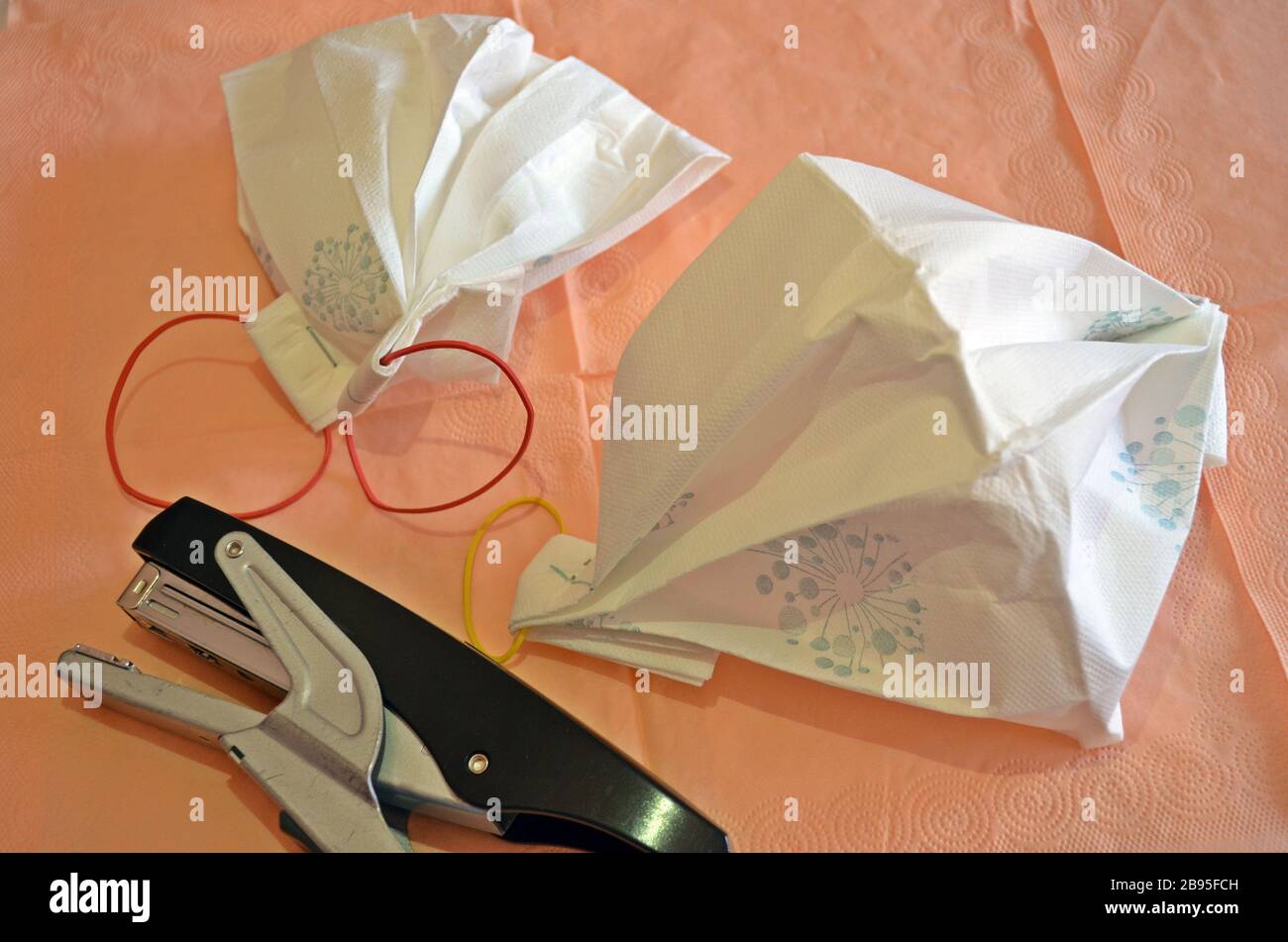 Two homemade DIY surgeon face masks made with napkins, rubber bands and ...