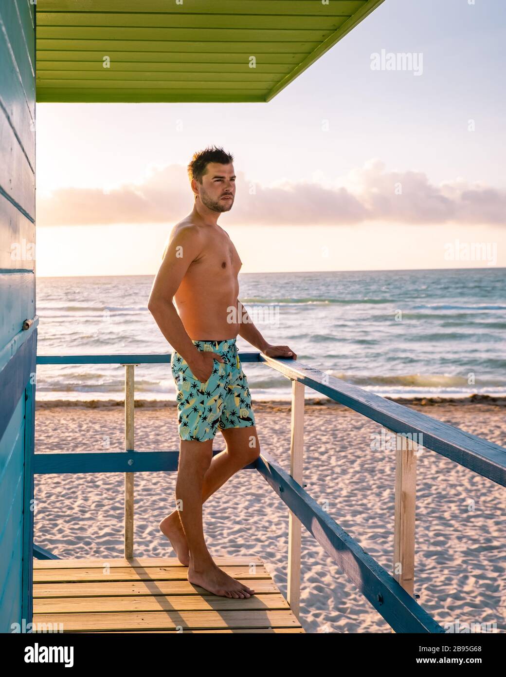 Miami beach Florida, young men on the beach with colorful lifeguard hut ...