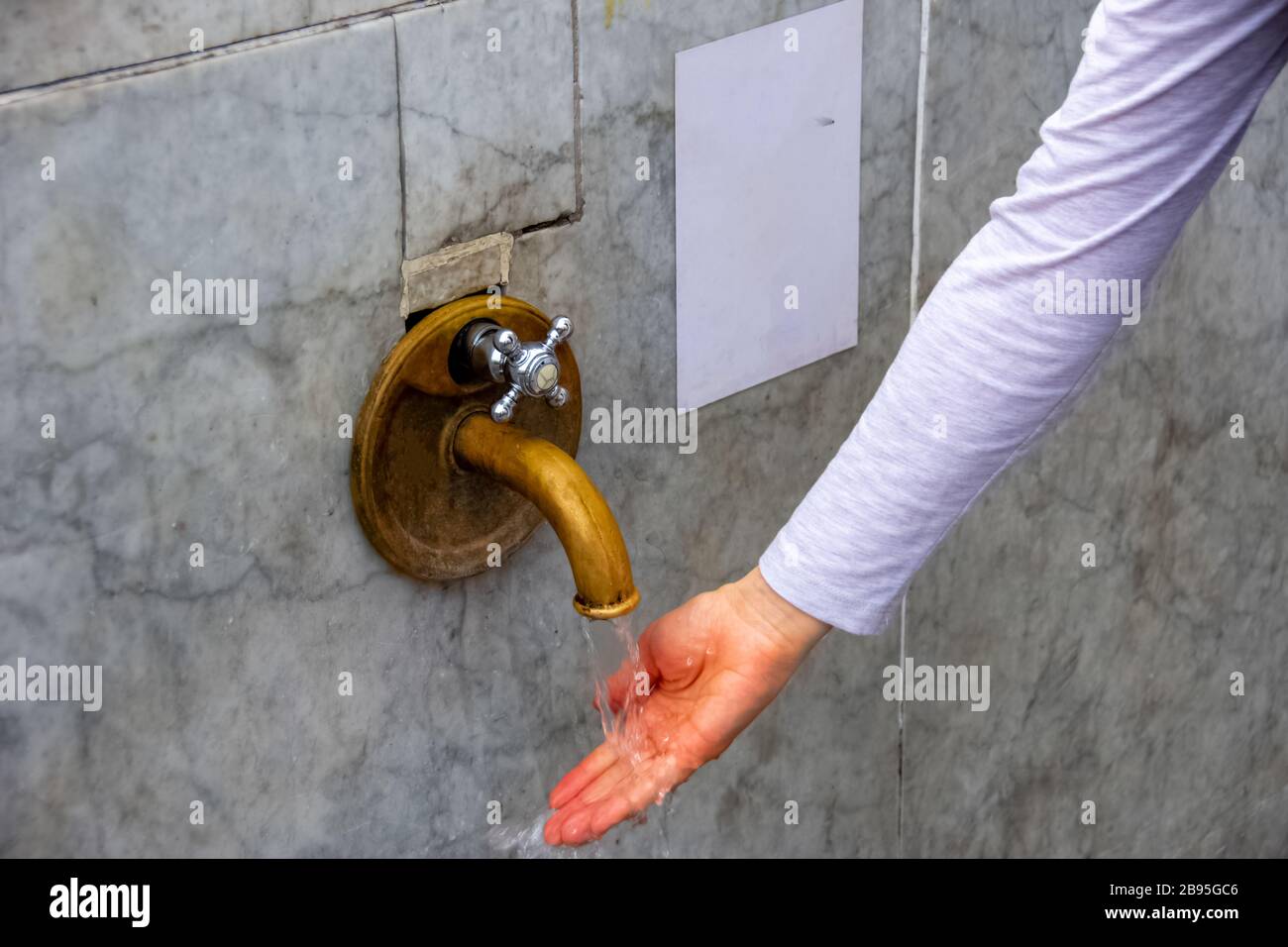 Girl closing the water tap on a public place Stock Photo - Alamy