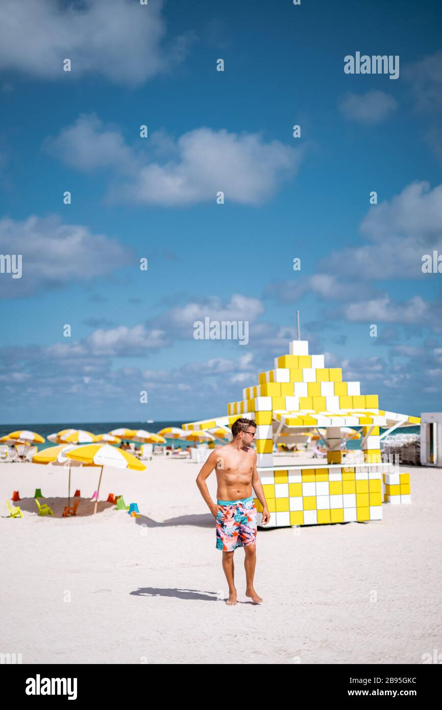 Miami beach Florida, young men on the beach with colorful lifeguard hut ...