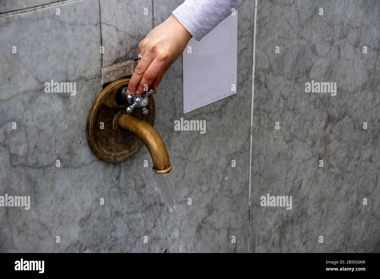 Girl closing the water tap on a public place Stock Photo - Alamy