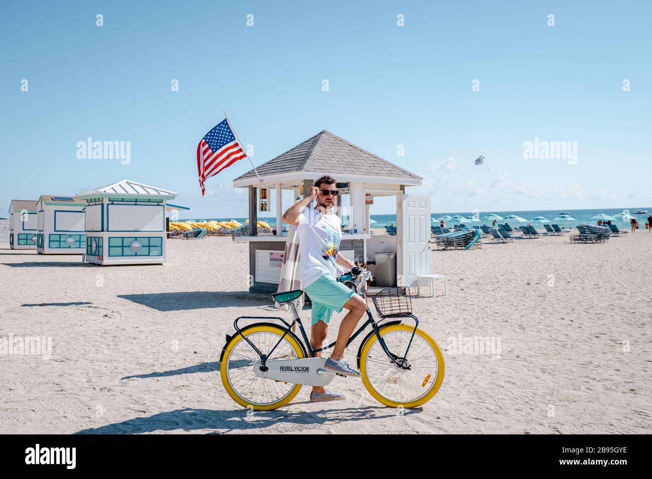 Miami beach Florida, young men on the beach with colorful lifeguard hut ...