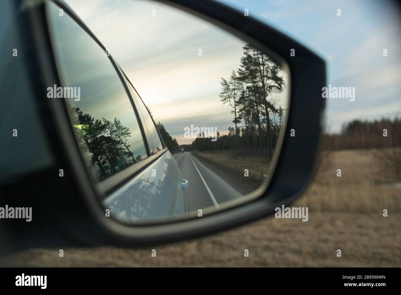 Reflection of the highway in a car mirror. Toned photo. Road travel ...