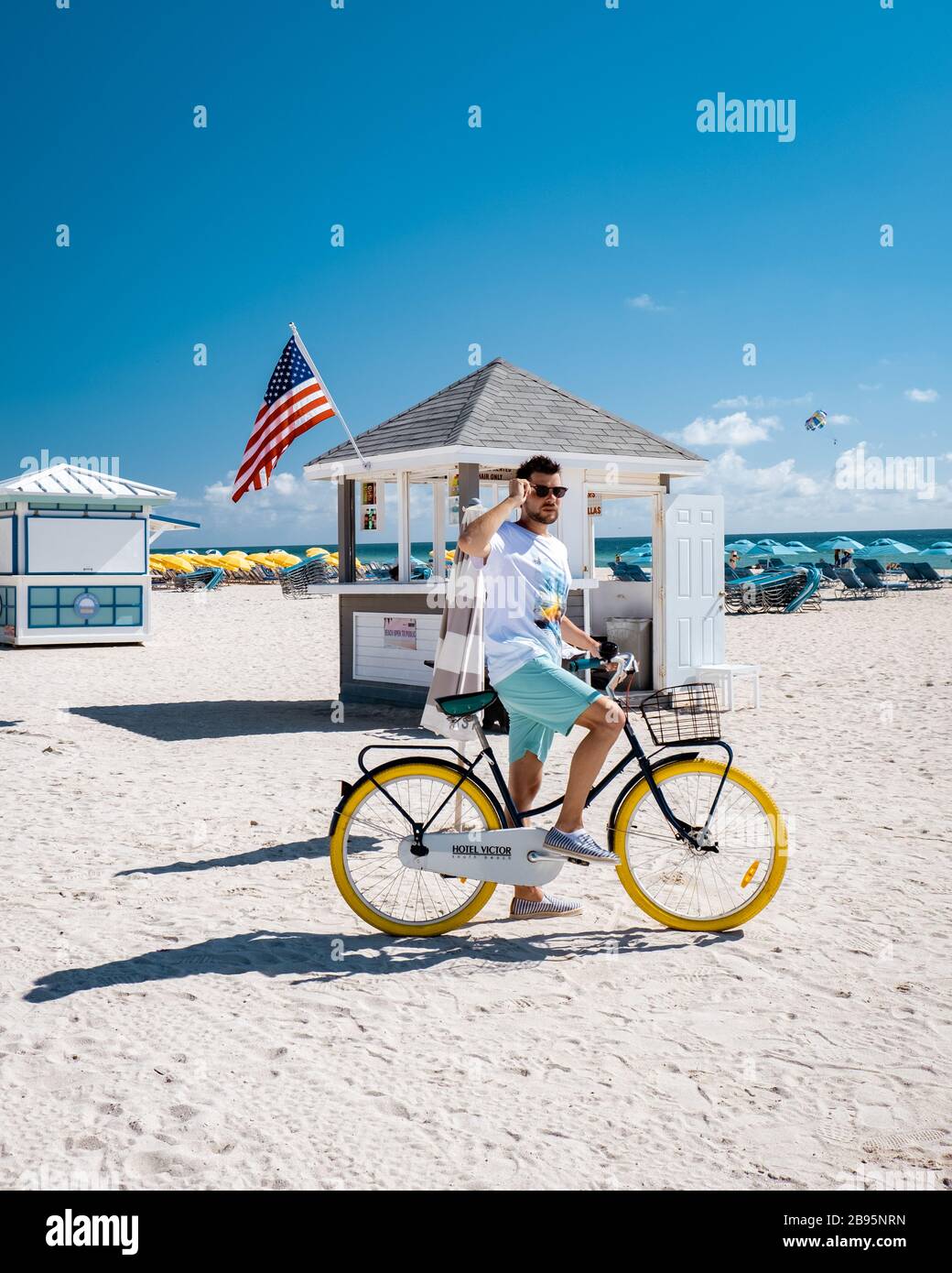 Miami beach Florida, young men on the beach with colorful lifeguard hut ...