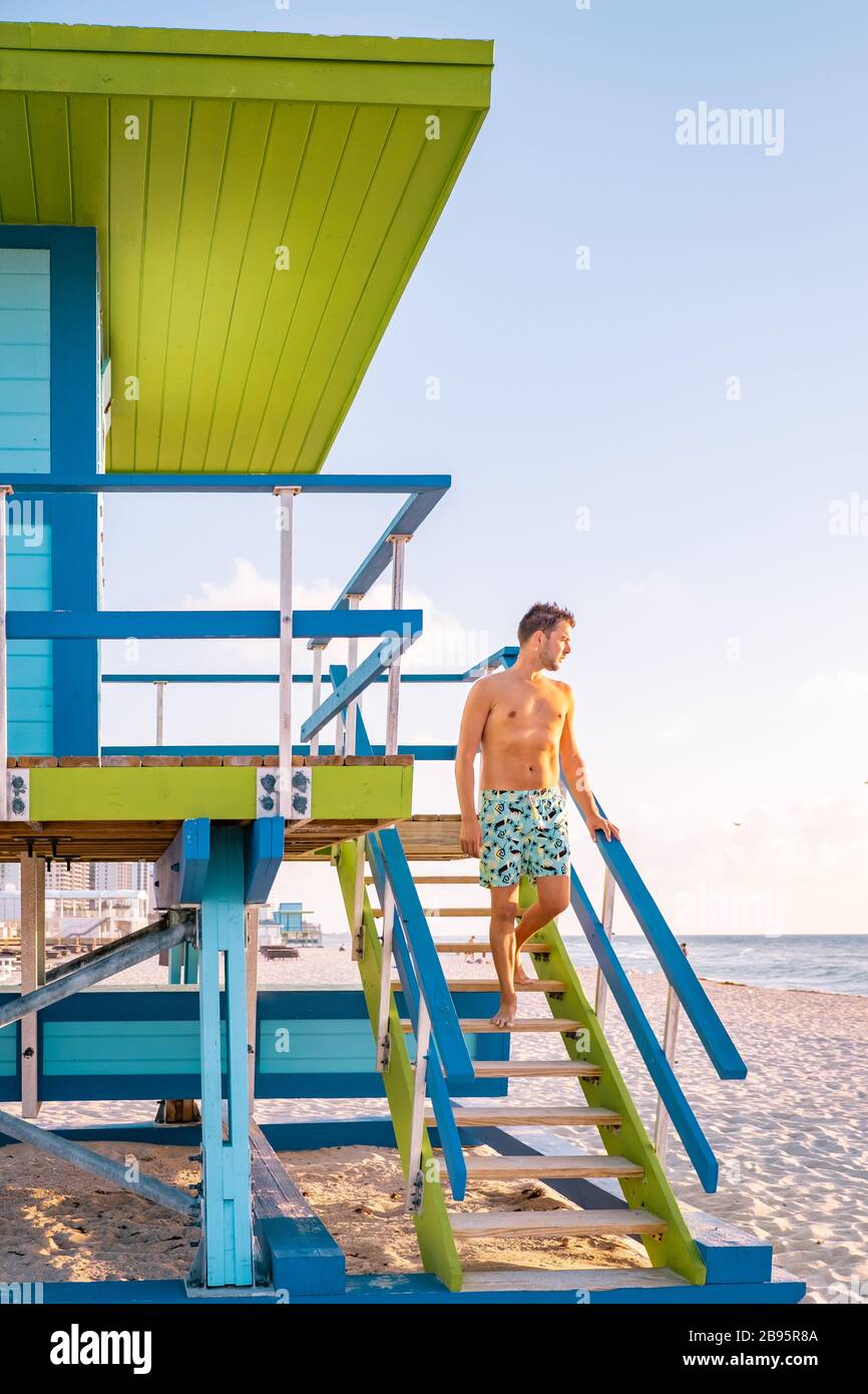 Miami beach Florida, young men on the beach with colorful lifeguard hut ...
