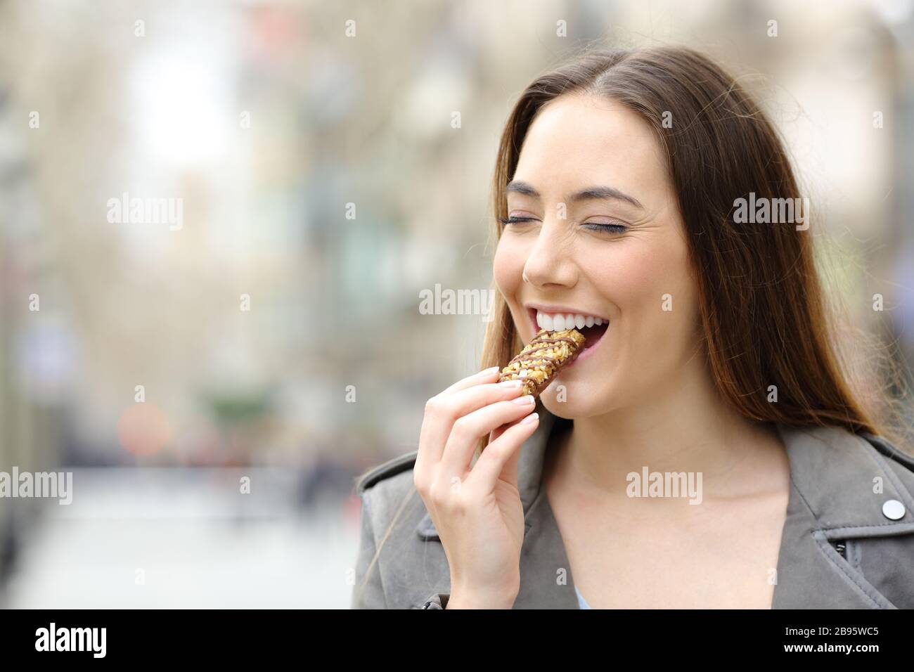 Front view portrait of a satisfied girl eating and enjoying a cereal ...