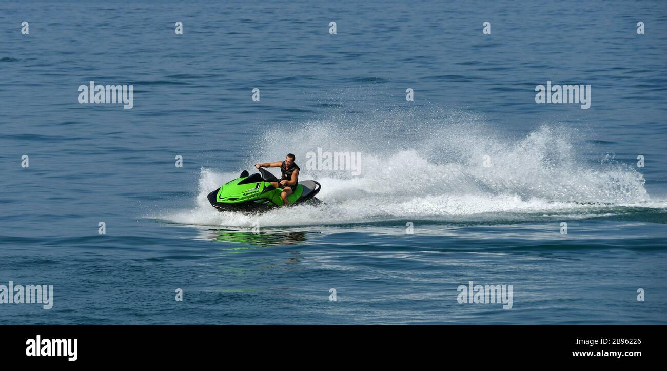 LAKE GARDA, ITALY - SEPTEMBER 2018: Person riding a fast jet ski ...