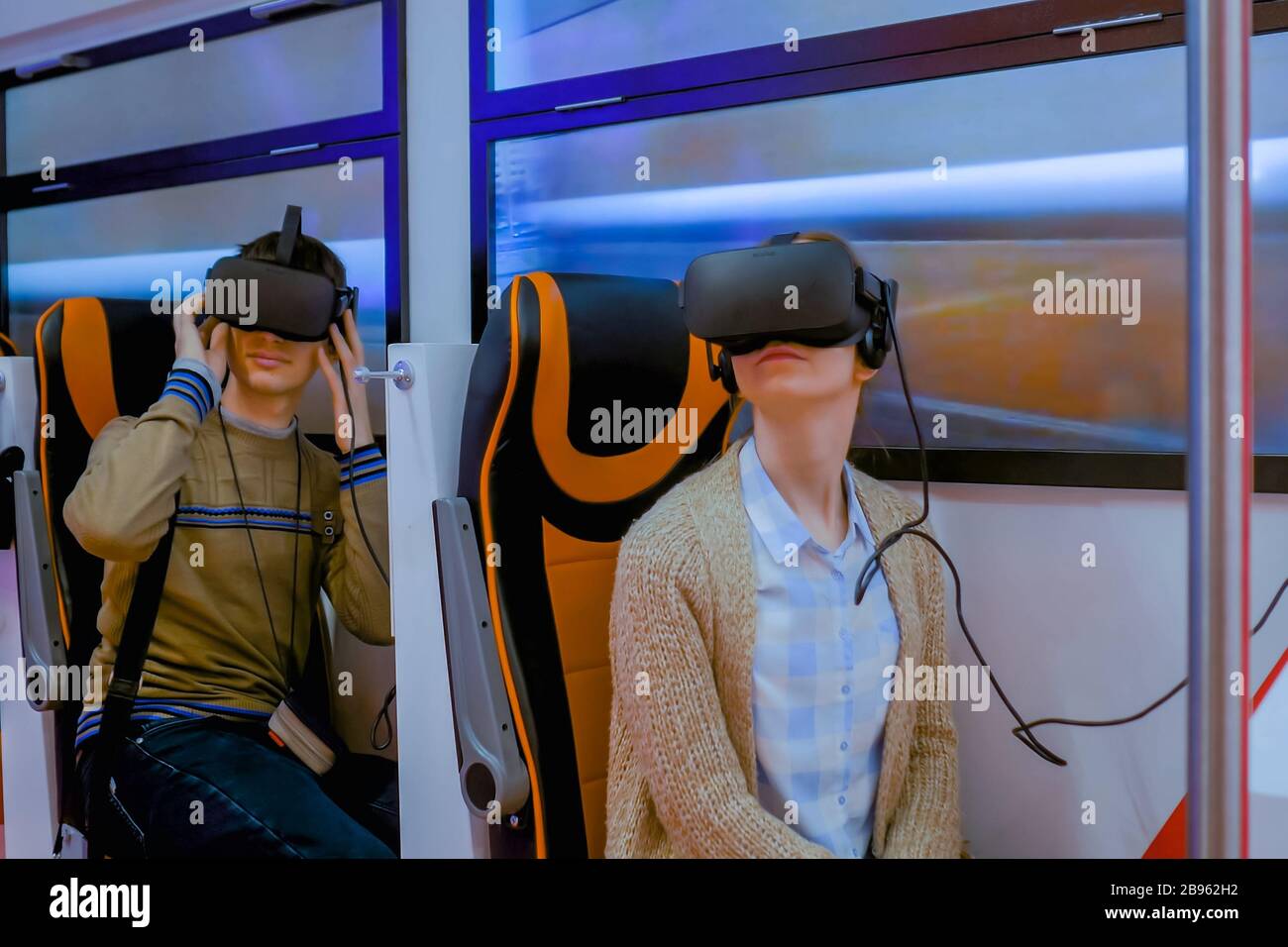 Young woman and man using virtual reality glasses and looking around ...