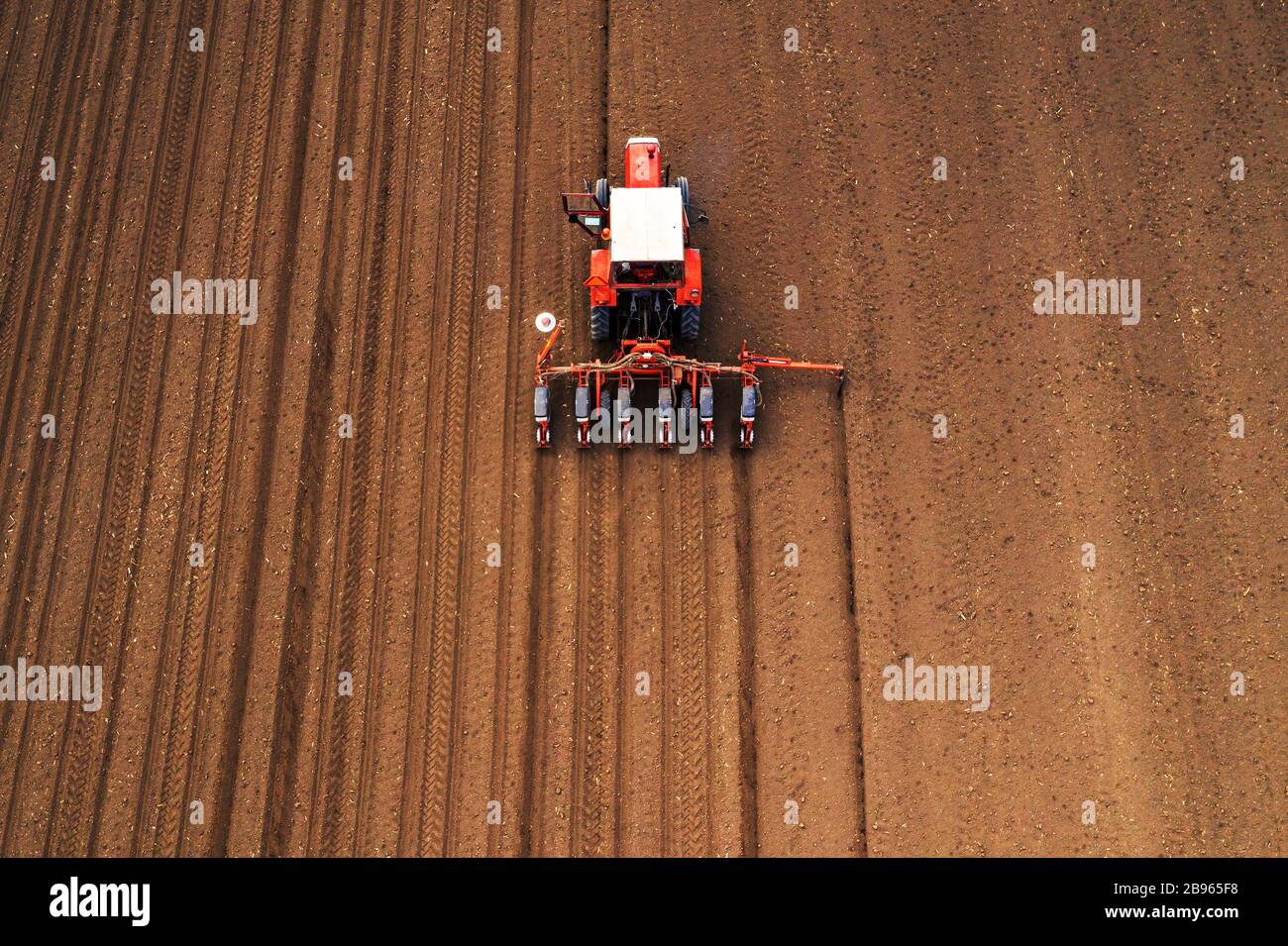 Drone photography of tractor with seeder working in field, agricultural ...