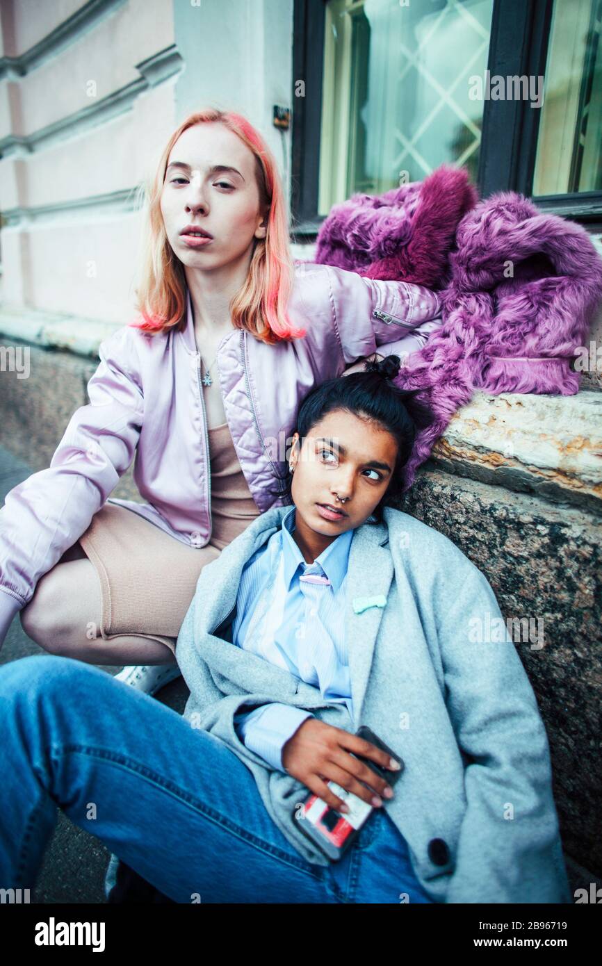Two teenage girls infront of university building smiling, having fun ...