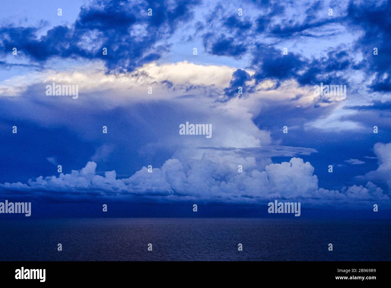 Unique bodies of cumulus thunderstorm clouds over ocean waters horizon ...