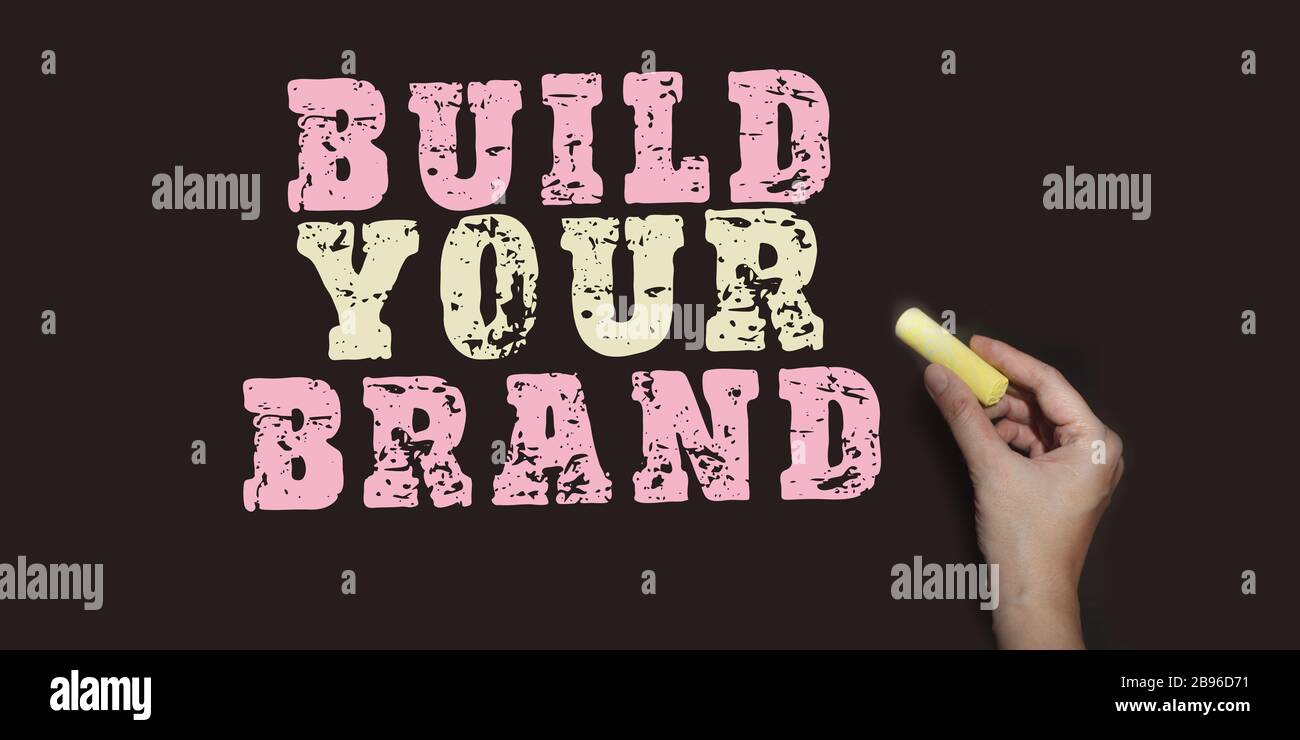 Concept image Build Your Brand written over blackboard with pink and ...